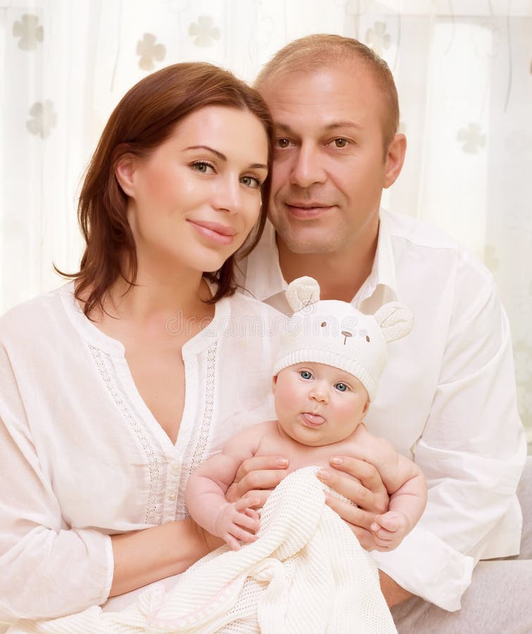 Padres con el bebé en casa foto de archivo. Imagen de sombrero - 35239806