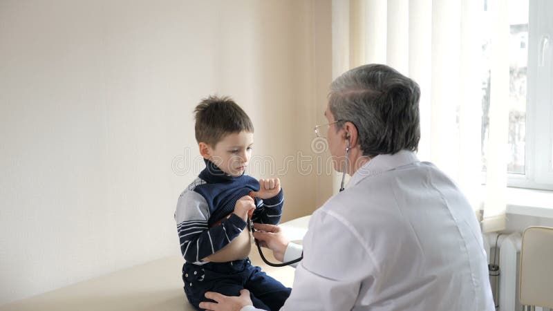 Paediatrician Man Examining Heartbeat of Kid Boy with Stethoscope Stock ...