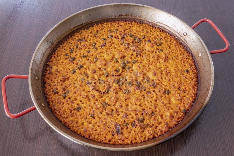Paella pan with squid rice stock photo. Image of menu - 219774350