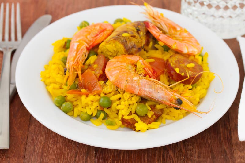 Paella in White Plate with Saffron Rice, Peas, Shrimps, Mussels, Squid ...