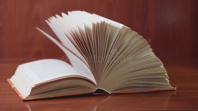 Pages of Open Textbook Sway in Light Breeze. Book Left on Table Stock ...