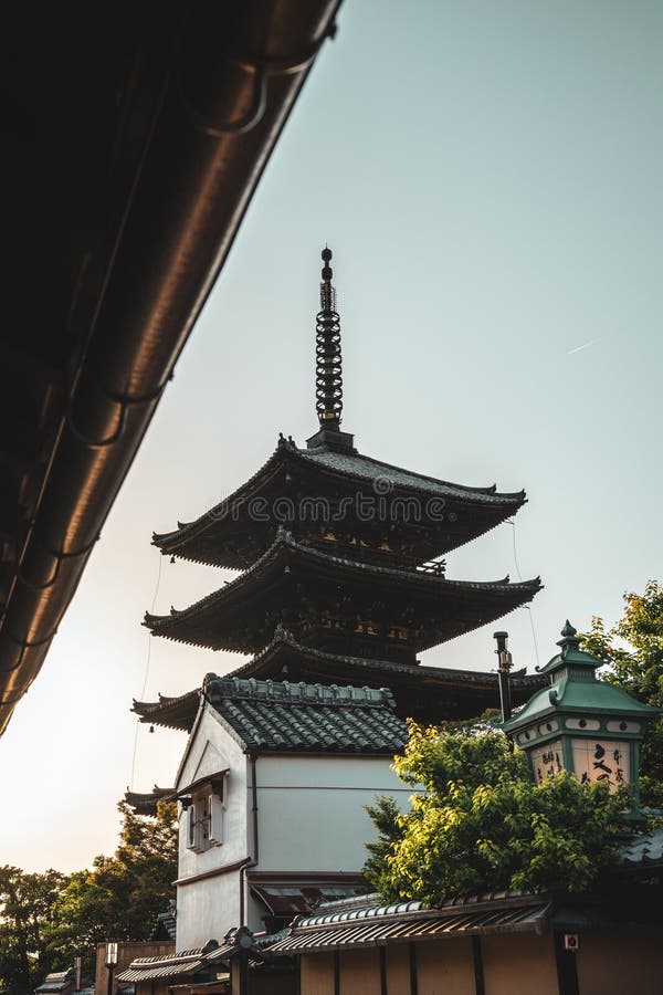 A Pagoda is Pictured at Sunset from the Ground Below the Buildings ...