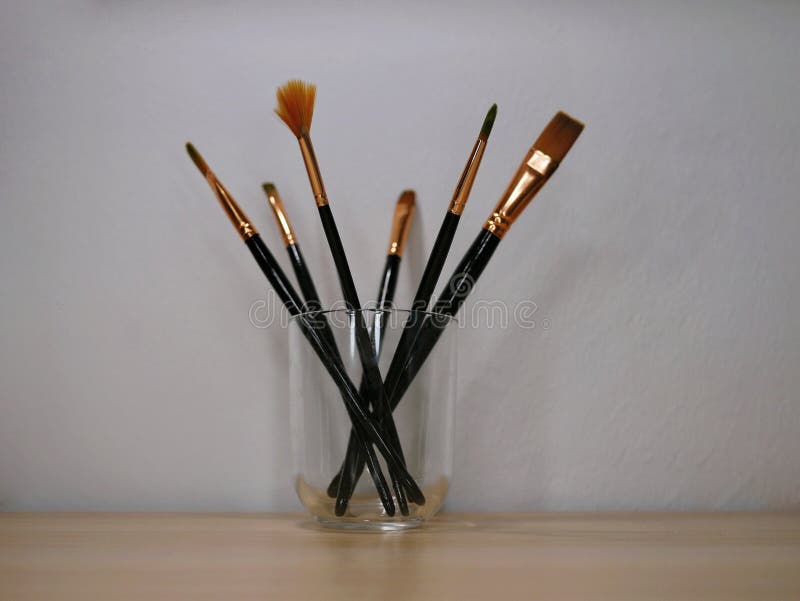 Paint Brushes in a Transparent Glass at the Background of a White Wall ...