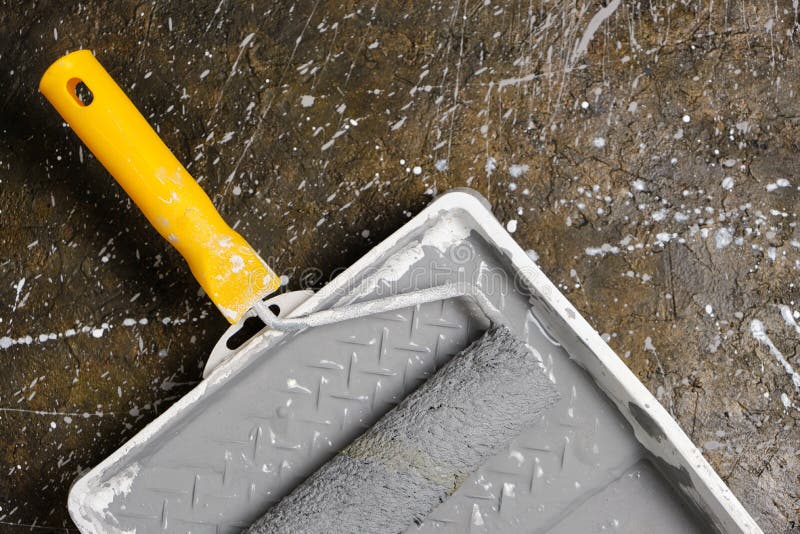 Paint Roller with Yellow Handle in Tray for Roller with Gray Paint on ...