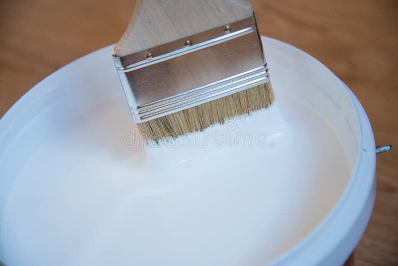 The Paintbrush in the White Paint. the Brush is Partially Submerged in ...