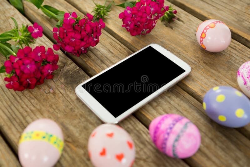 Painted Easter Eggs, Flowers and Mobile Phone on Wooden Surface Stock ...