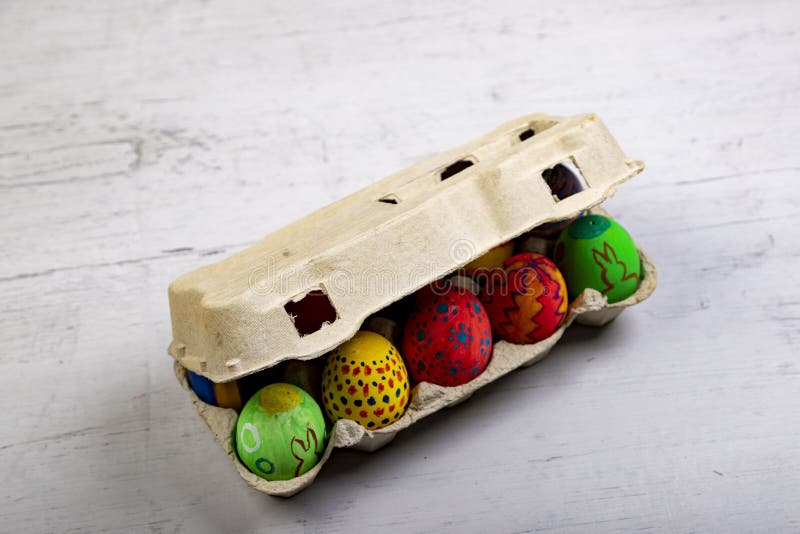 Painted Eggs with Easter Motives in a Closed Egg Carton on a Wooden ...