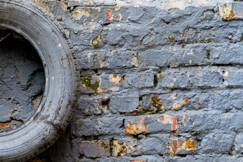 Painted in Grey Tyre Lies on the Gray Brick Wall Stock Image - Image of ...