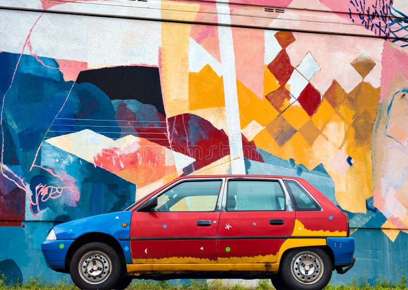 A Painted Old Car Against the Background of a Multi-colored Wall ...