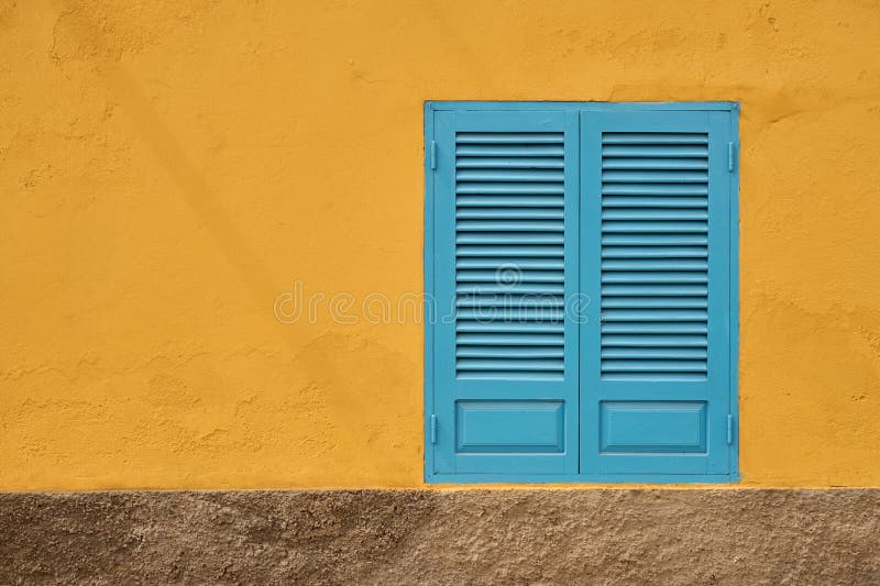 A Painted Yellow Wall with a Blue Window. Stock Photo - Image of show ...