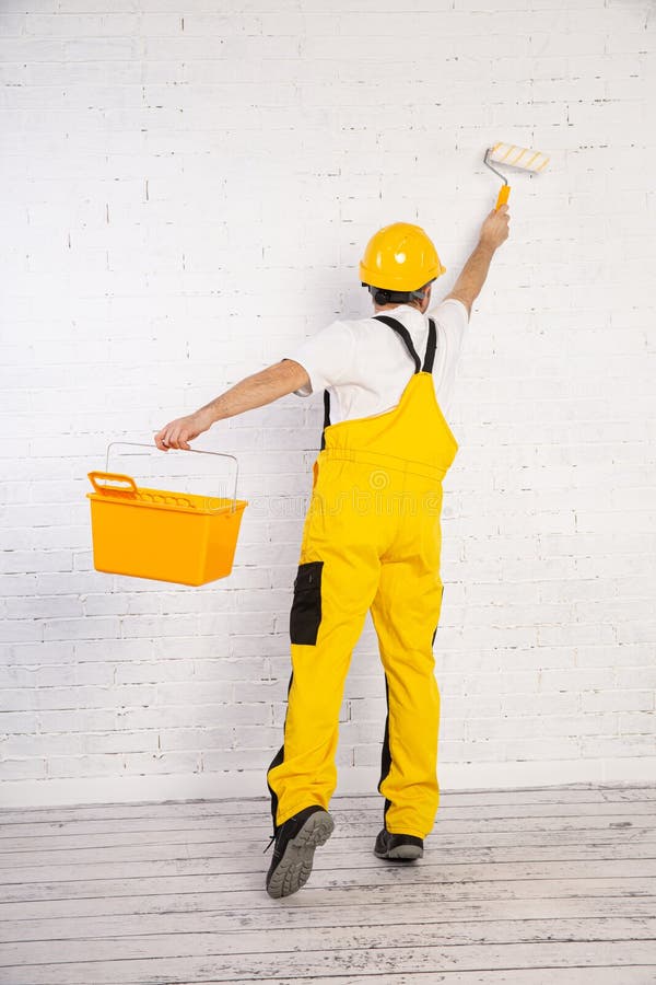 Painter on a Construction Site while Doing His Job. he is Dressed in ...