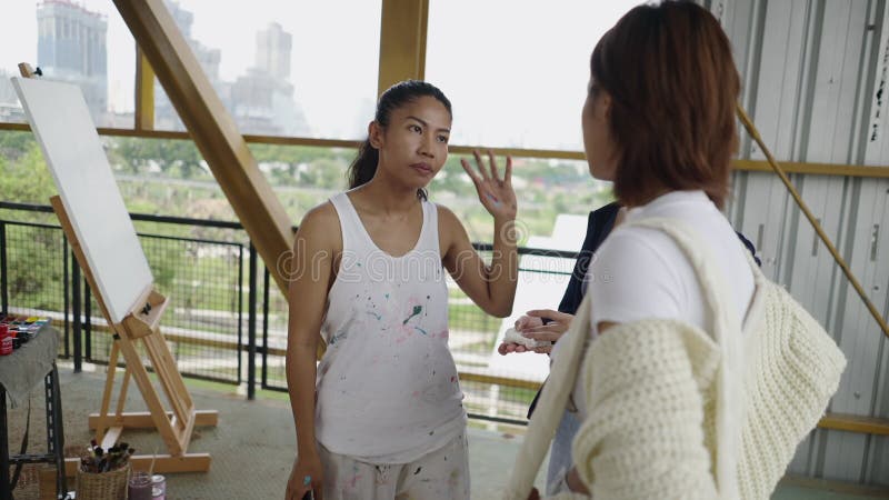 A Painter Explains Something To Two Girls Stock Video - Video of canvas ...