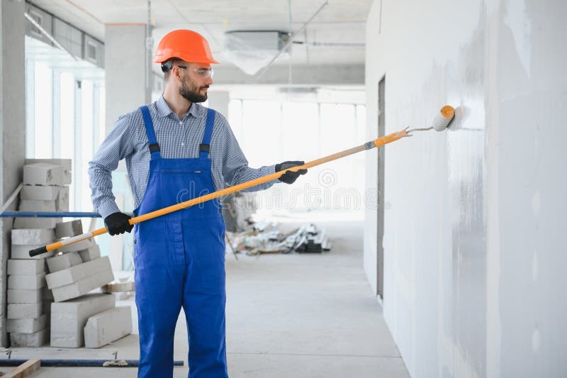 Painter in Uniform Paints the Wall. Stock Image - Image of decorator ...