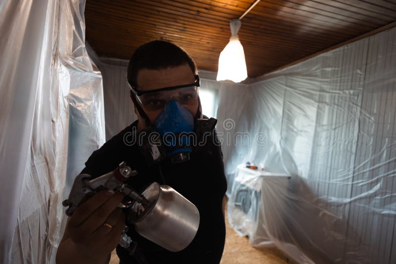 Painter Wearing Protective Gear and Using a Spray Gun for Home ...