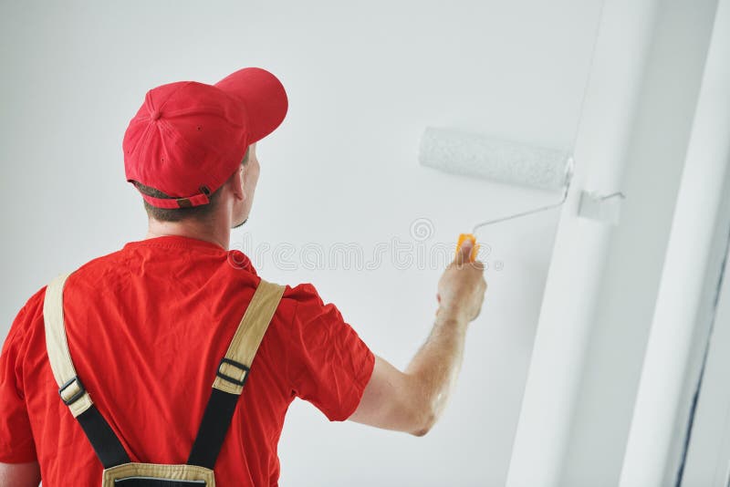Painter Worker with Roller Painting Wall Surface into White Stock Image ...