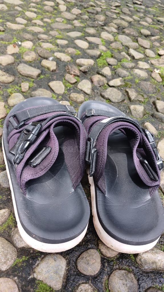 A Pair of Black and White Sandals on a Rocky Floor Stock Image - Image ...