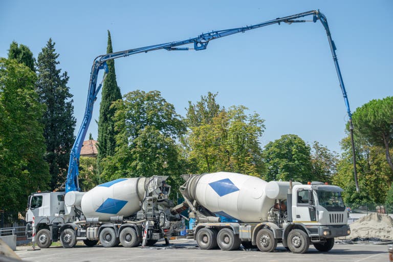 Pair of Cement Trucks with Extended Hydraulic Systems Pouring Cement ...