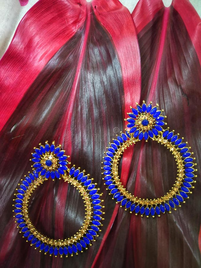 Pair of Ear Rings in Blue and Golden Color on Two Red Leafs Stock Photo ...