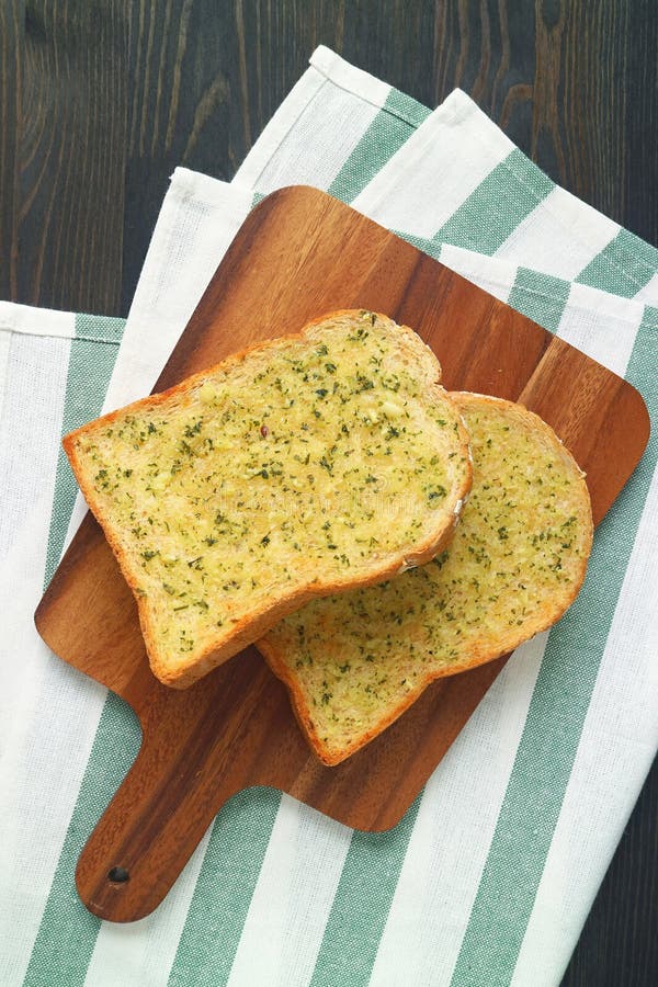 Pair of Garlic Butter Toasts on Wooden Breadboard on Wooden Table Stock ...