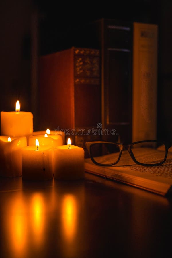 Pair Of Glasses On An Open Book On The Table With Burning Candles On It Stock Image Image Of