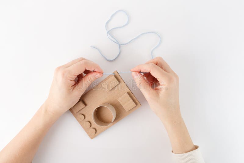 A Pair of Hands Holding a Piece of Light Blue Yarn and Threading it ...