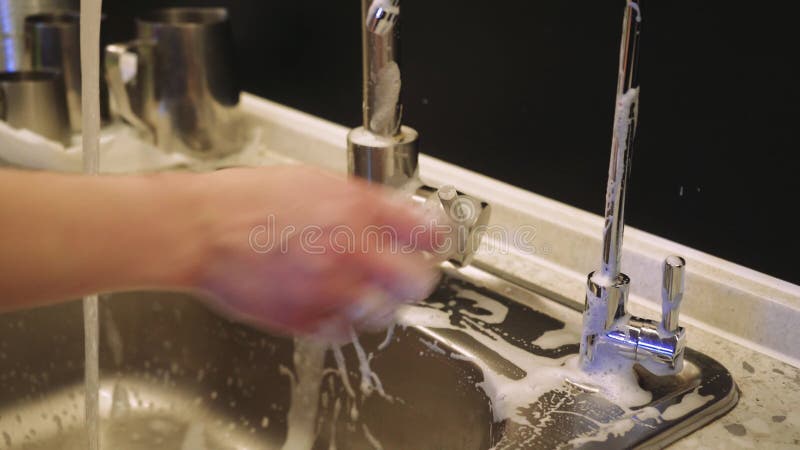 A Pair of Hands Washes a Stainless Steel Kitchen Surface with a Sponge ...