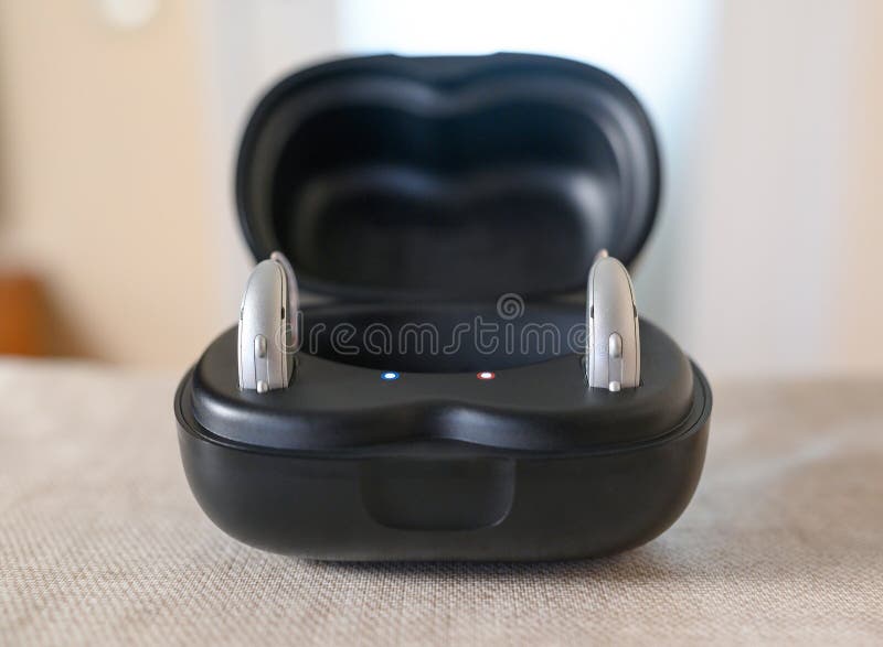 Hearing Aid Devices Charging in Black Case on Table Stock Image - Image ...