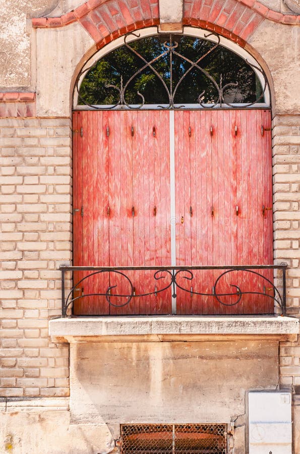 Pair of Hinged and Folding, Red, Weathered, Doors with an Iron Railing ...