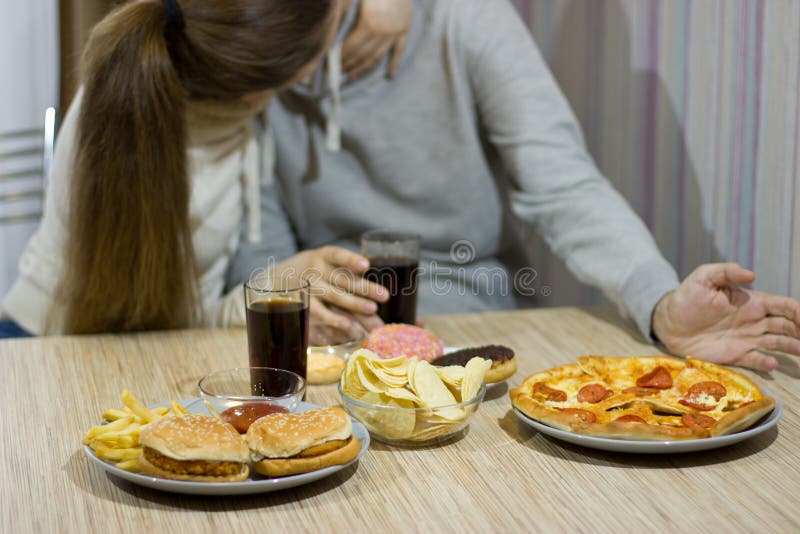 A Pair of Lovers Sit at the Table and Eat Fast Food. Stock Photo ...