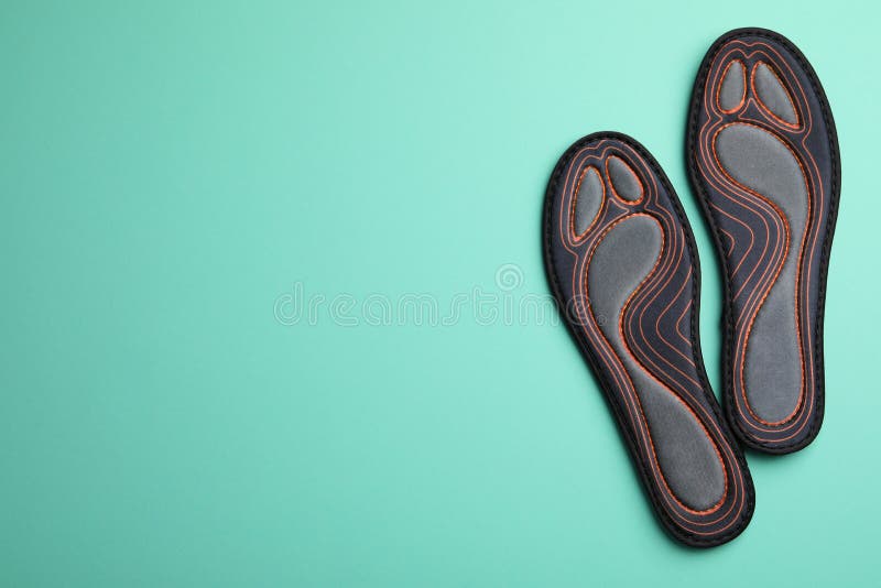 Pair of Orthopedic Insoles on Turquoise Background, Flat Lay. Space for ...