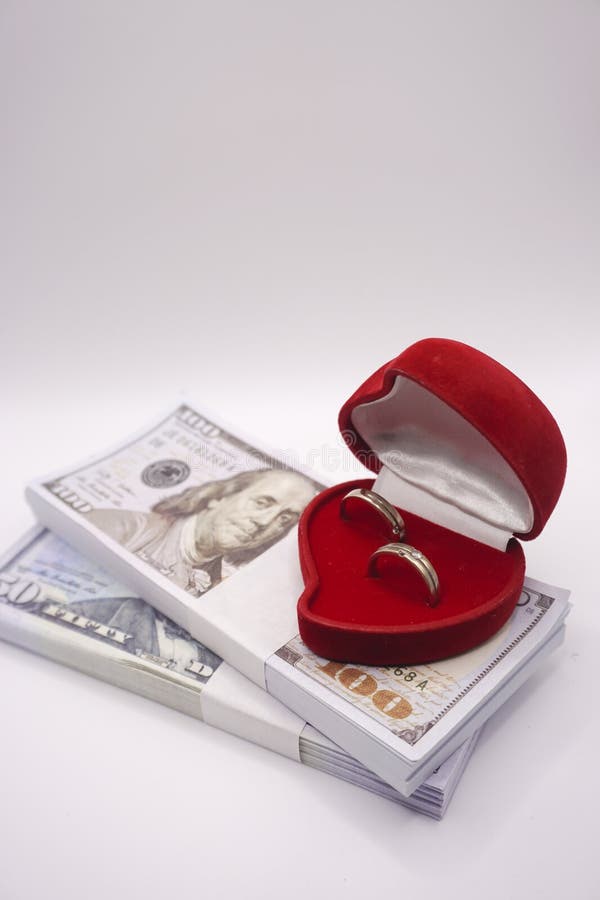 A Pair of Rings in a Ring Case, on Top of a Wad of $100 Bills and a Wad ...