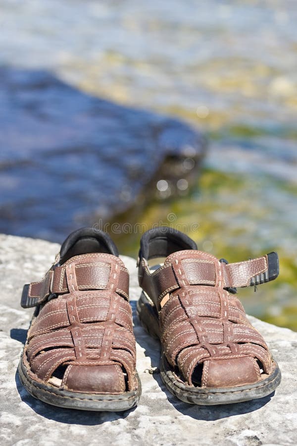 Pair of Sandals on Rock with Water in Background Stock Photo - Image of ...