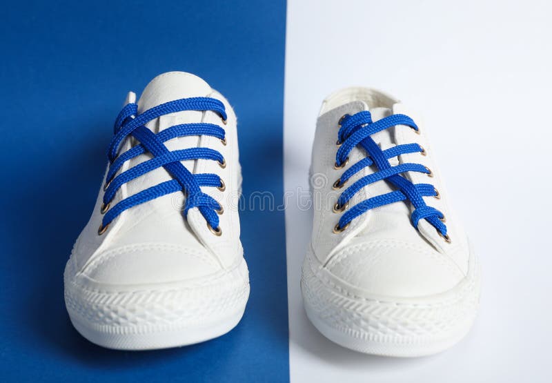 Pair of Stylish Shoes with Blue Laces on Color Background Stock Photo ...