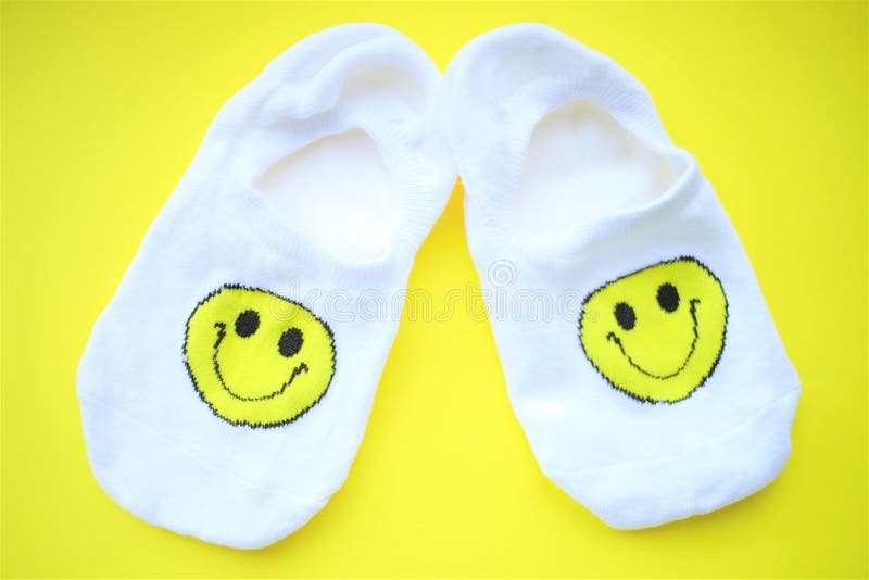 Pair of White Socks with a Smiley Face on a Yellow Table Stock Image ...