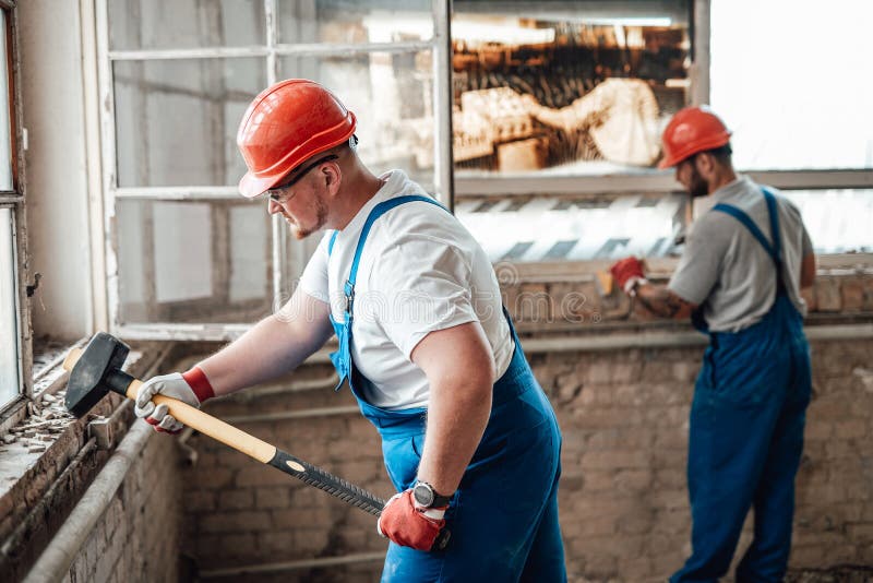A Pair of Workers are Working To Remove Plaster from the Old Walls ...
