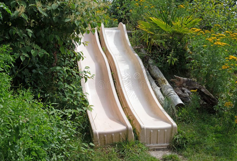 Pair of Slides on a Green Slope Stock Image - Image of child ...