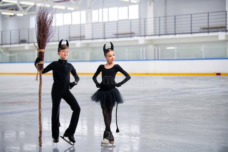 Pair of Young Figure Skaters Dressed As Devils Pose with a Broom at an ...