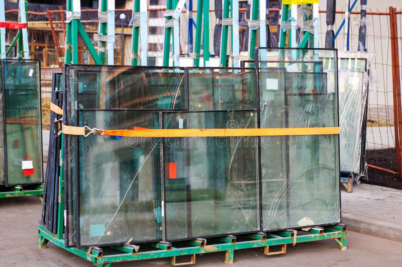 A Pallet of Glass is on the Ground by a Building Under Construction ...