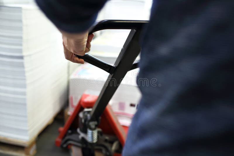 Pallet Truck, the Worker Loads the Pallets Onto the Trolley. Stock ...