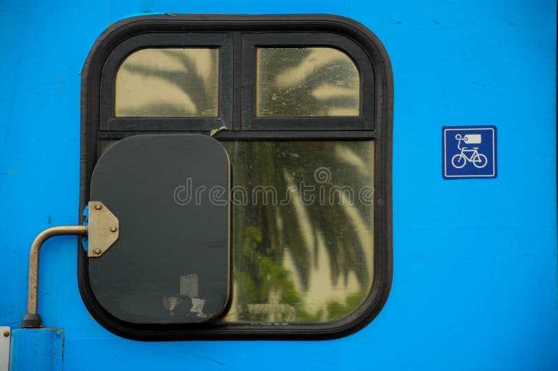 Palm Tree Reflections in Train Window with Bike Sign Against Blue ...