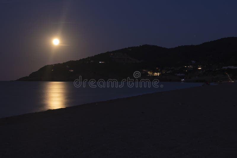 Beach at Night with the Full Moon Rising Over the Horizon Stock Image ...