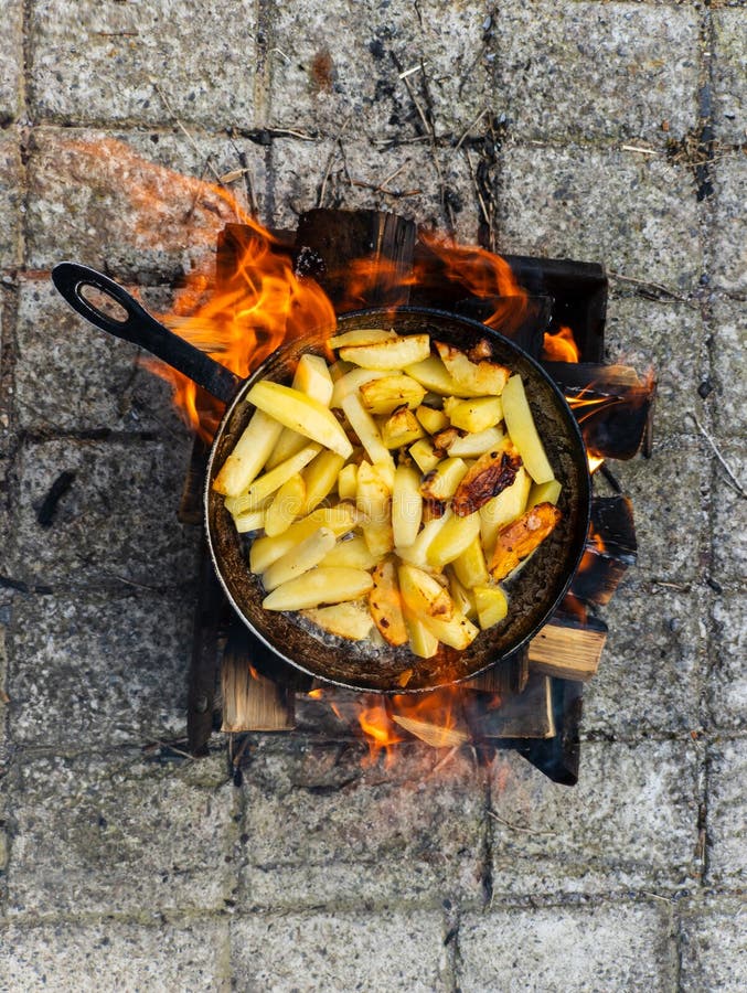 A Pan Filled with Potatoes Sitting on Top of a Fire Stock Image - Image ...