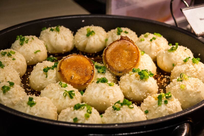 A Pan of Pan Fried Chinese Buns with Spring Onion and Sesame Seeds on ...