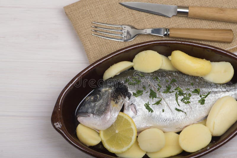 A Pan with Raw Fish Standing Near Fork and Knife. Horizontal Studio ...