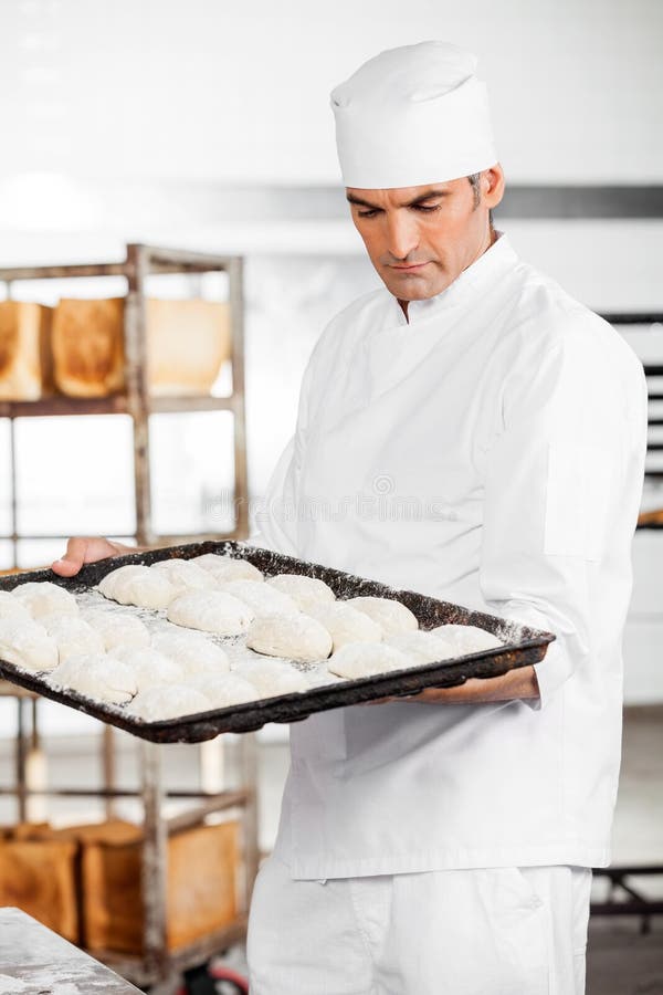 Panadero Holding Baking Tray while Standing in Bakery Imagen de archivo ...