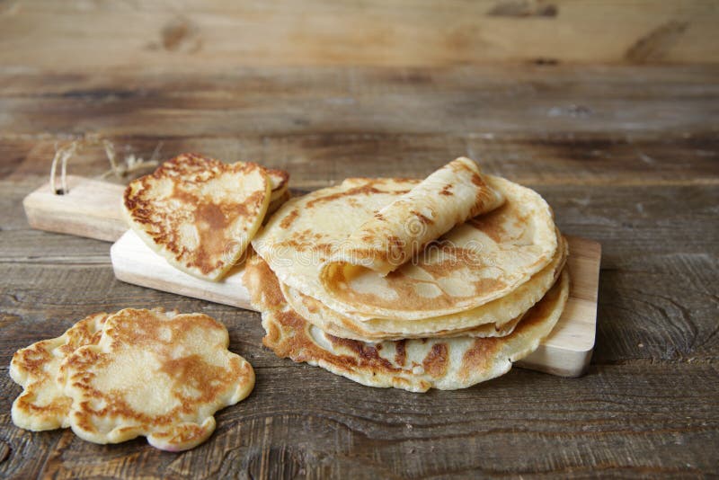 Pancakes of Different Shapes on a Board on a Rustic Wooden Table with ...