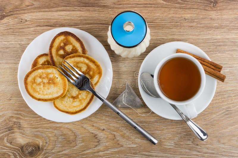 Pancakes, Fork, Cup of Tea, Cinnamon, Sugar and Teaspoon Stock Photo ...