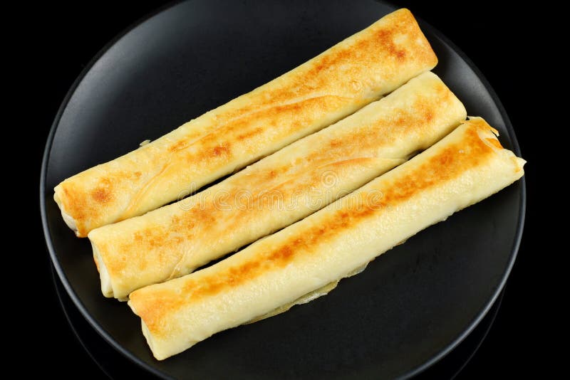 Pancakes Rolls on a Black Plate. Stuffed Thin Pancakes Rolled Stock ...