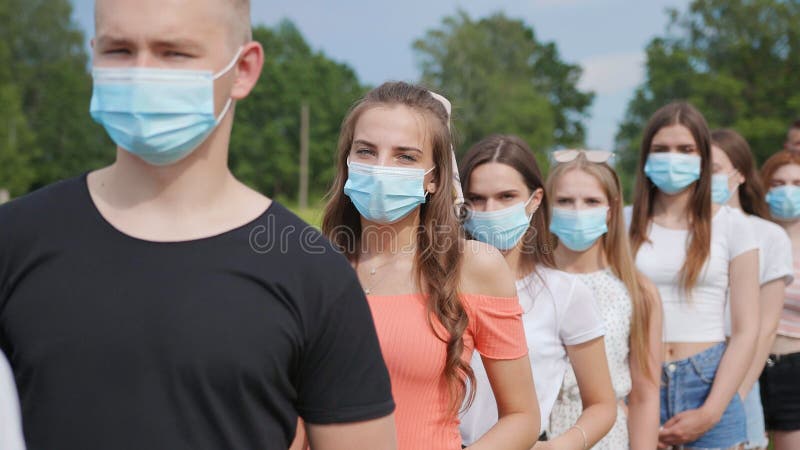 Pandemic Concept. a Group of Students Stand in a Row in Masks. Stock ...
