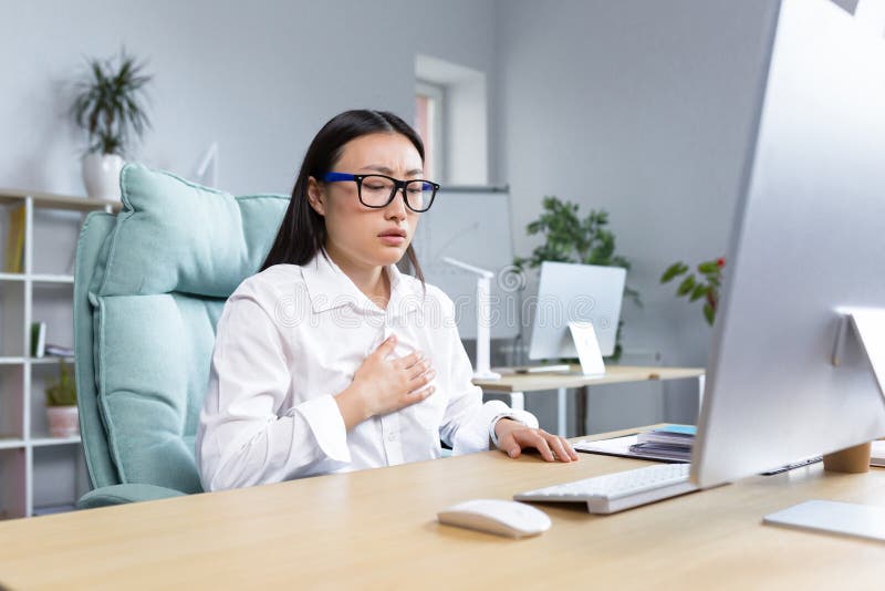 Panic Attack in the Workplace. an Asian Woman in Office, Holding Chest ...